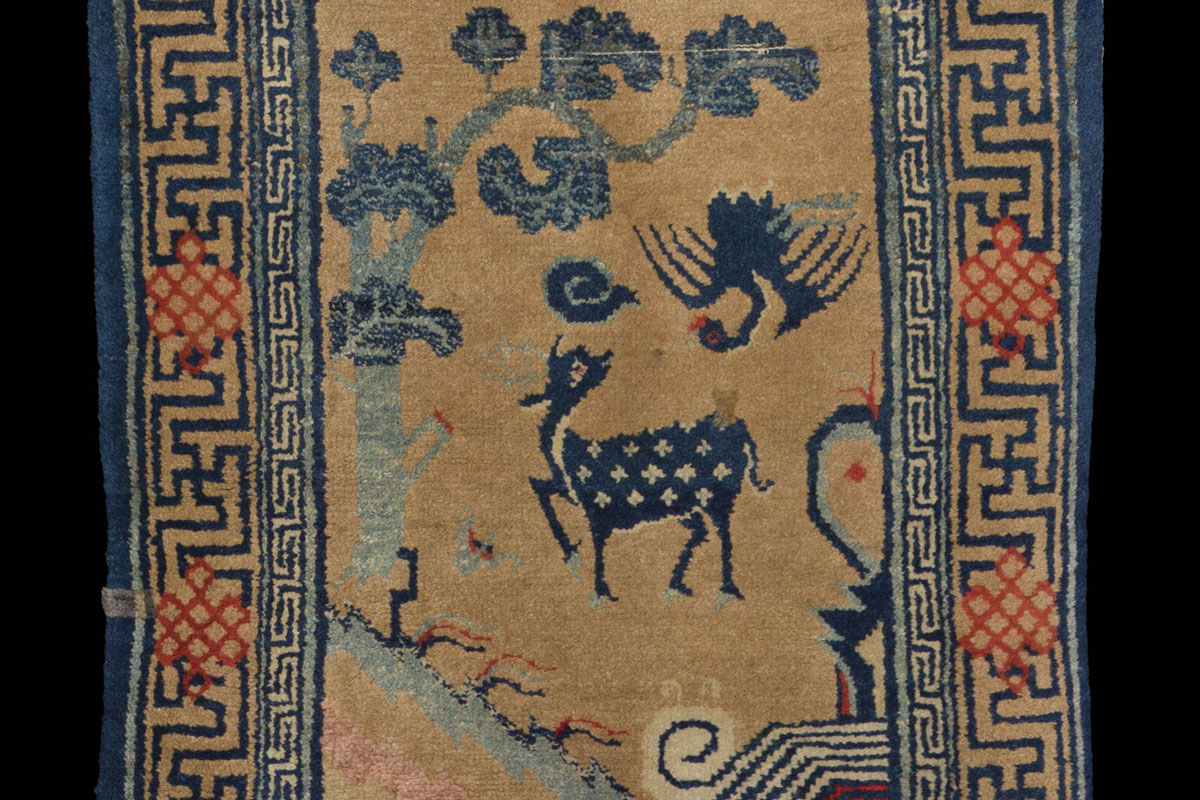A Chinese saddle rug with deer and crane on caramel ground, 19th century